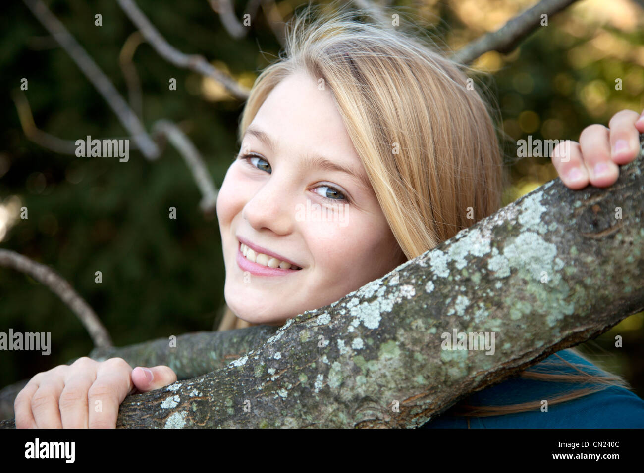 Smiling Girl Holding Tree Limb Stock Photo - Alamy