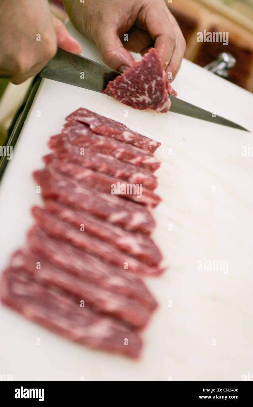 A butcher prepares slices Wagyu beef for sale at a branch of Uny ...