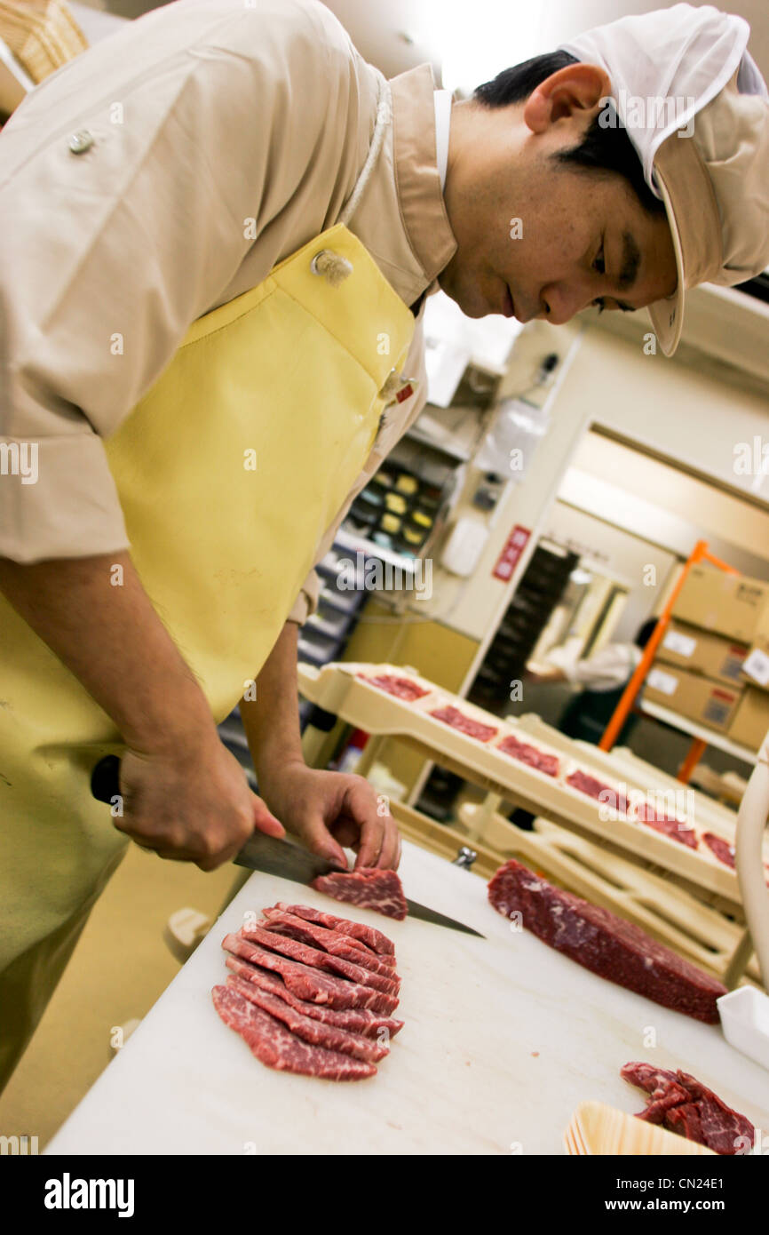 A butcher prepares slices Wagyu beef for sale at a branch of Uny ...