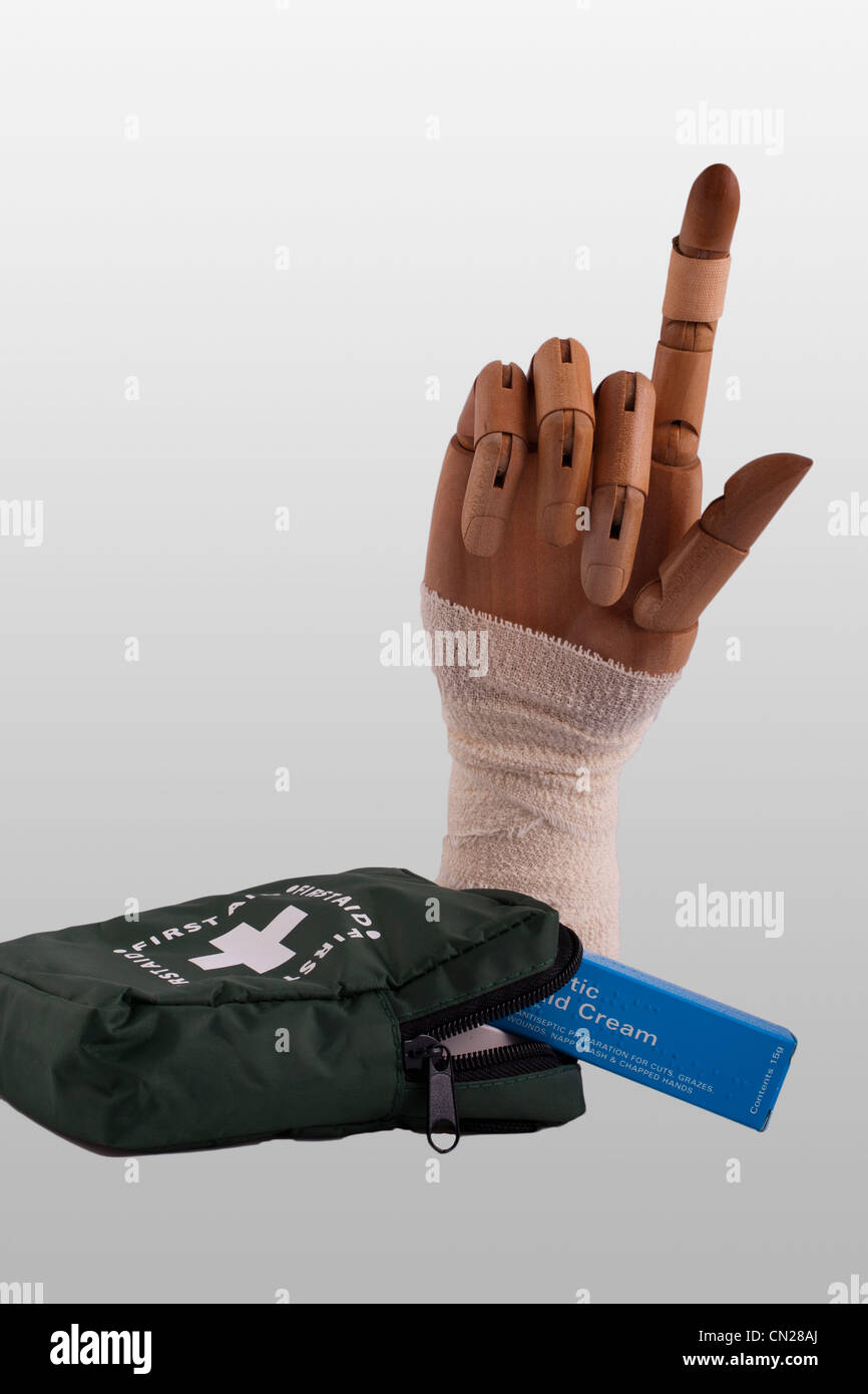 First Aid applied to a wooden hand with a first aid kit in the ...