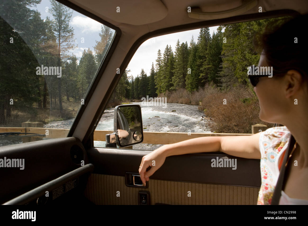 Woman looking through car window at forest scenery Stock Photo - Alamy