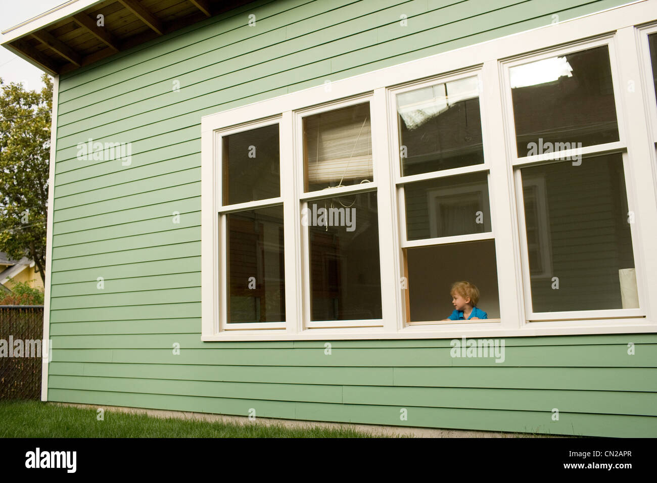 Young boy looking out of window Stock Photo - Alamy