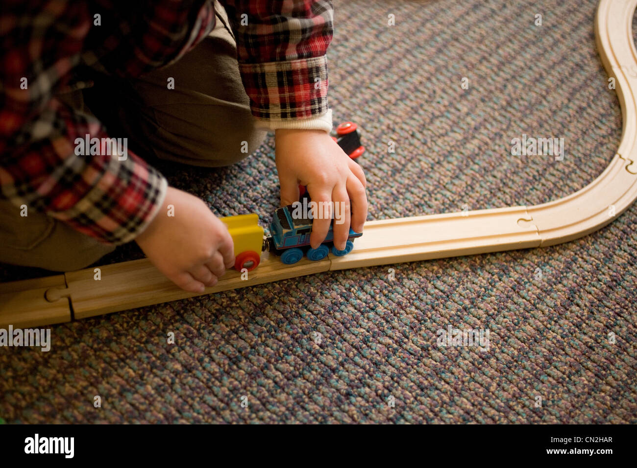 Young boy playing with train set Stock Photo - Alamy