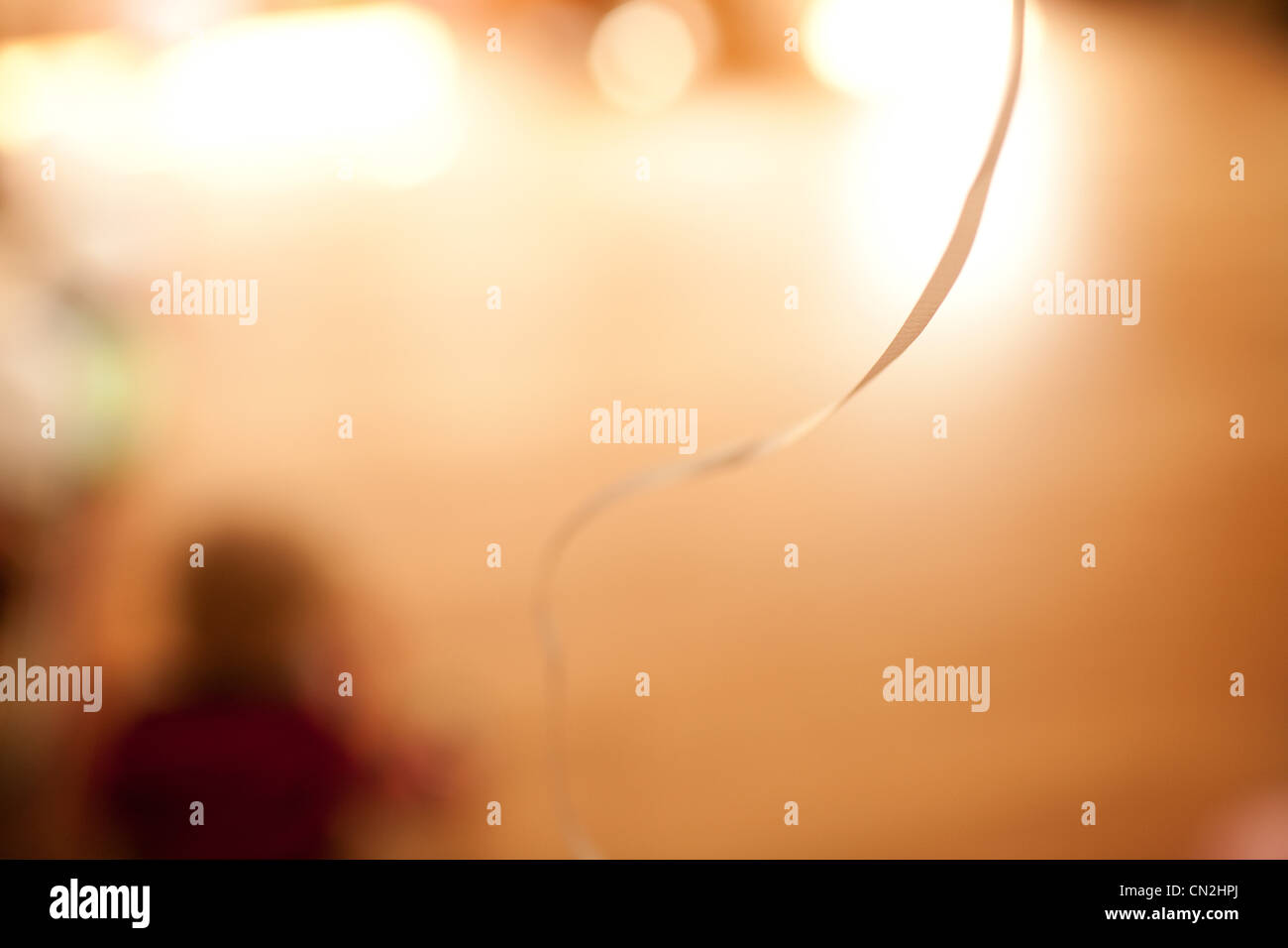 Blurred figure sitting on floor with balloon ribbon Stock Photo - Alamy