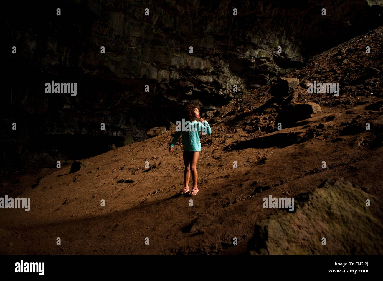 Girl in dark cave Stock Photo - Alamy