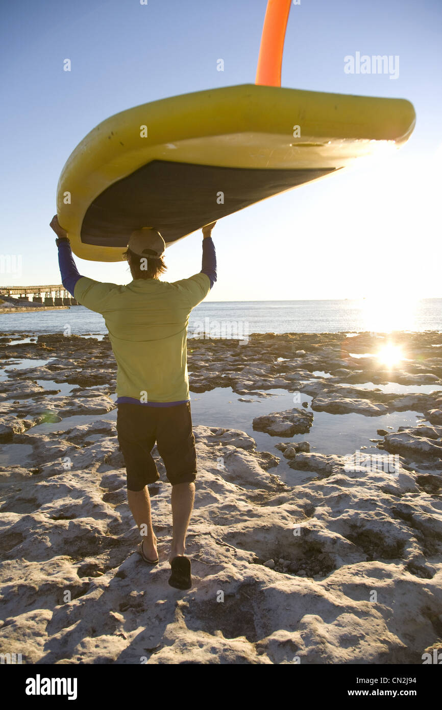 Man Carrying Paddleboard on Beach, Florida Keys, USA Stock Photo - Alamy