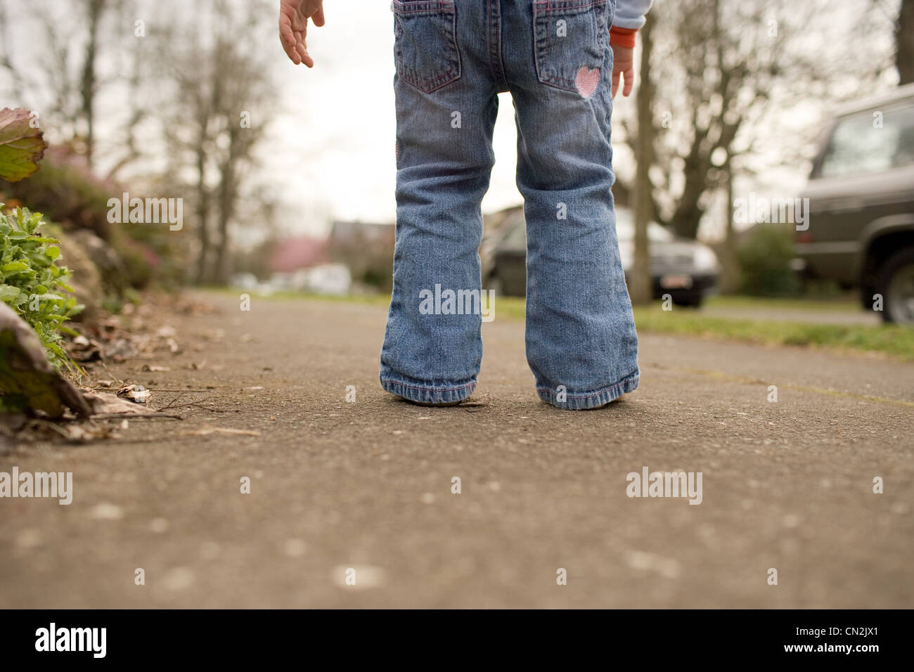 Young girl standing on pavement Stock Photo - Alamy