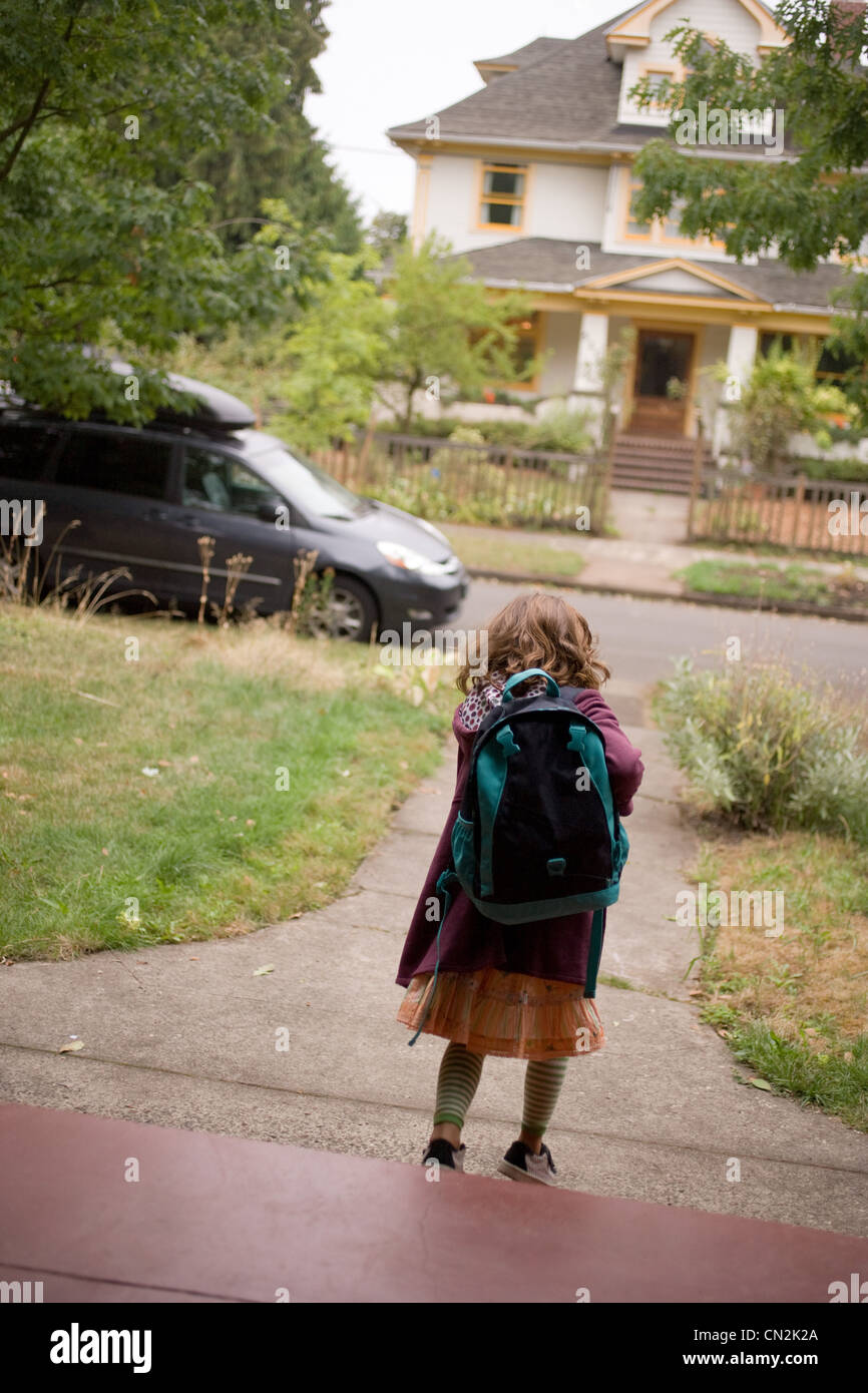 Girl wearing backpack walking down path Stock Photo - Alamy