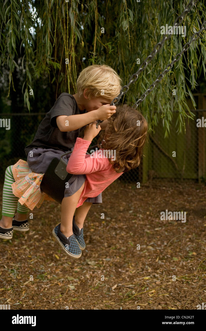 Two children on swing Stock Photo - Alamy