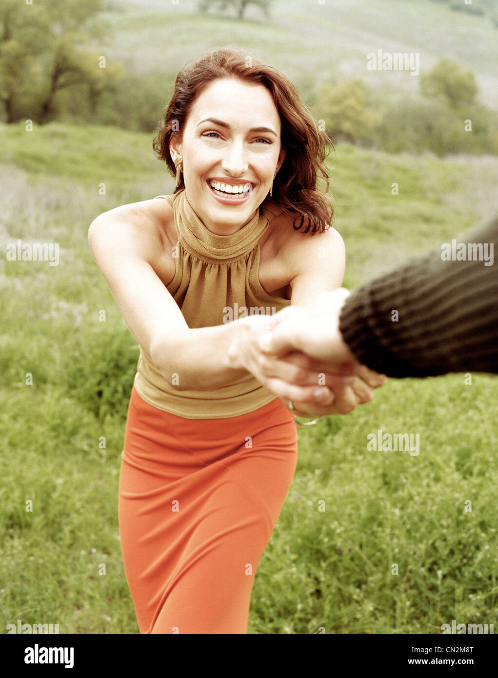 Man helping woman up hill Stock Photo - Alamy