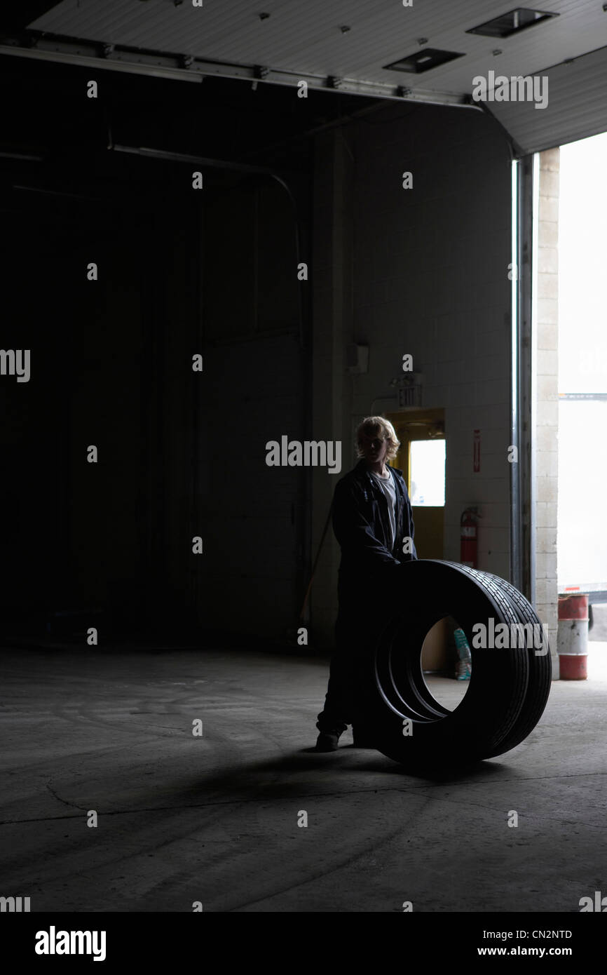 Worker Moving Tires in a Warehouse Stock Photo - Alamy