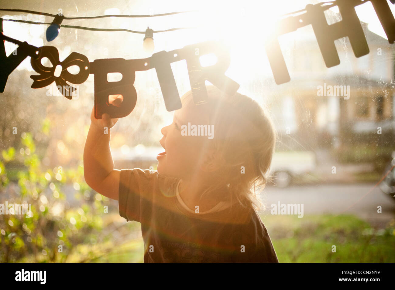 Young boy touching birthday party banner Stock Photo - Alamy