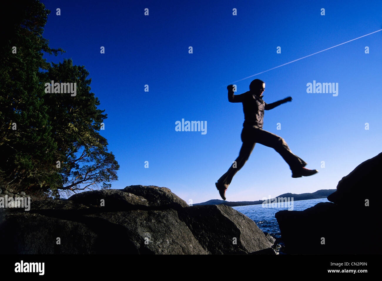 Woman Jumping across Boulders, East Sooke Park, near Victoria, BC Stock ...