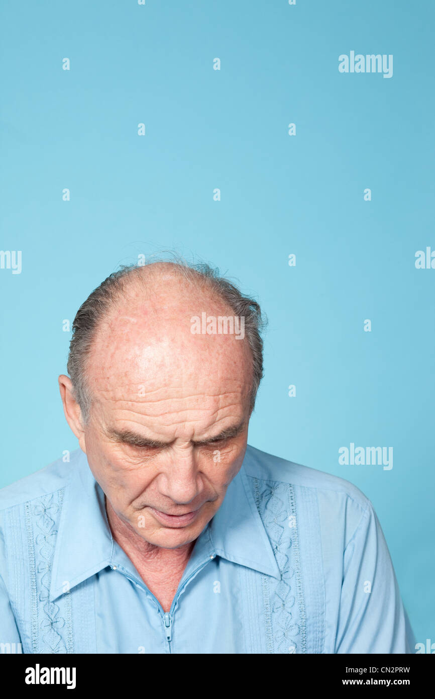 Senior man looking down, studio shot Stock Photo - Alamy