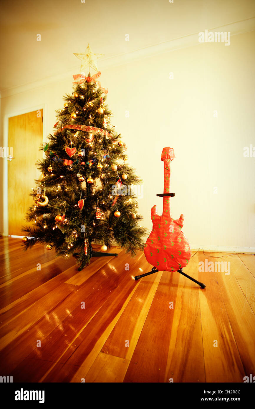 Chrismas wrapped guitar present and tree Stock Photo - Alamy