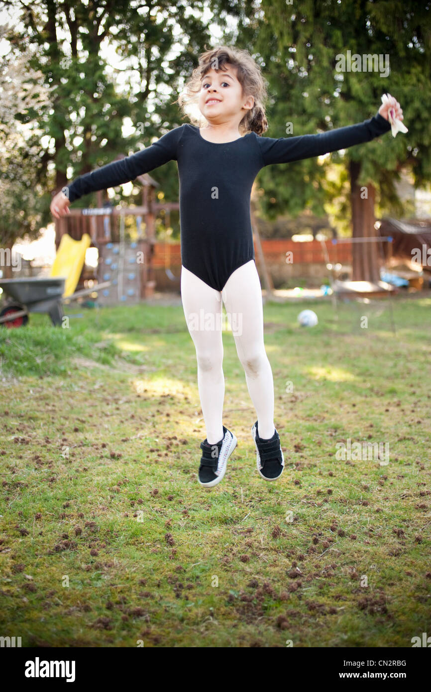 Young girl jumping in garden Stock Photo - Alamy