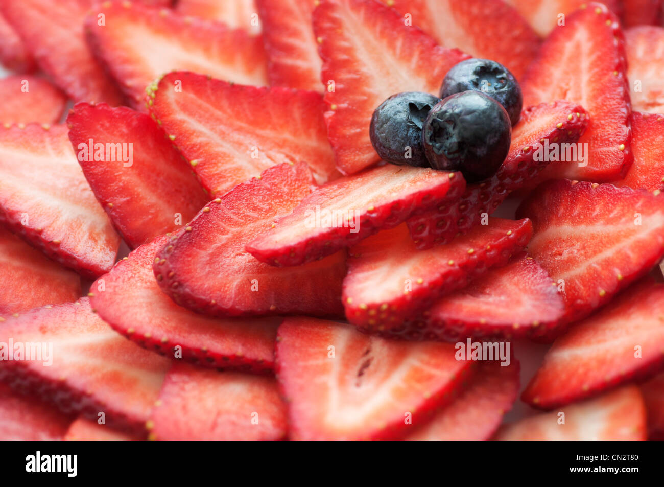 Fresh slices of strawberry arranged with blueberries Stock Photo - Alamy
