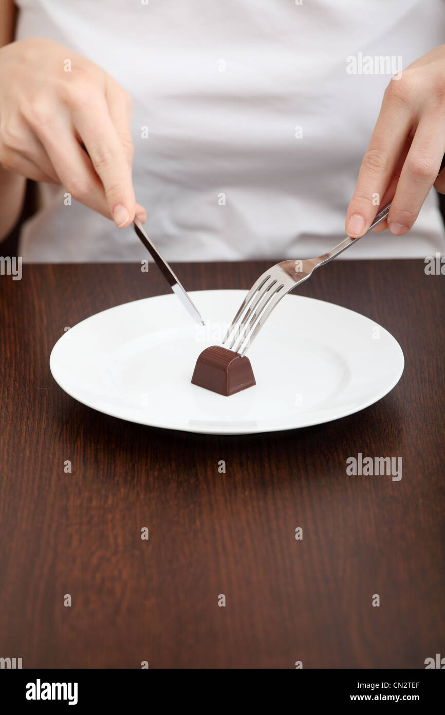 Woman's eating chocolade praline. In home Stock Photo - Alamy