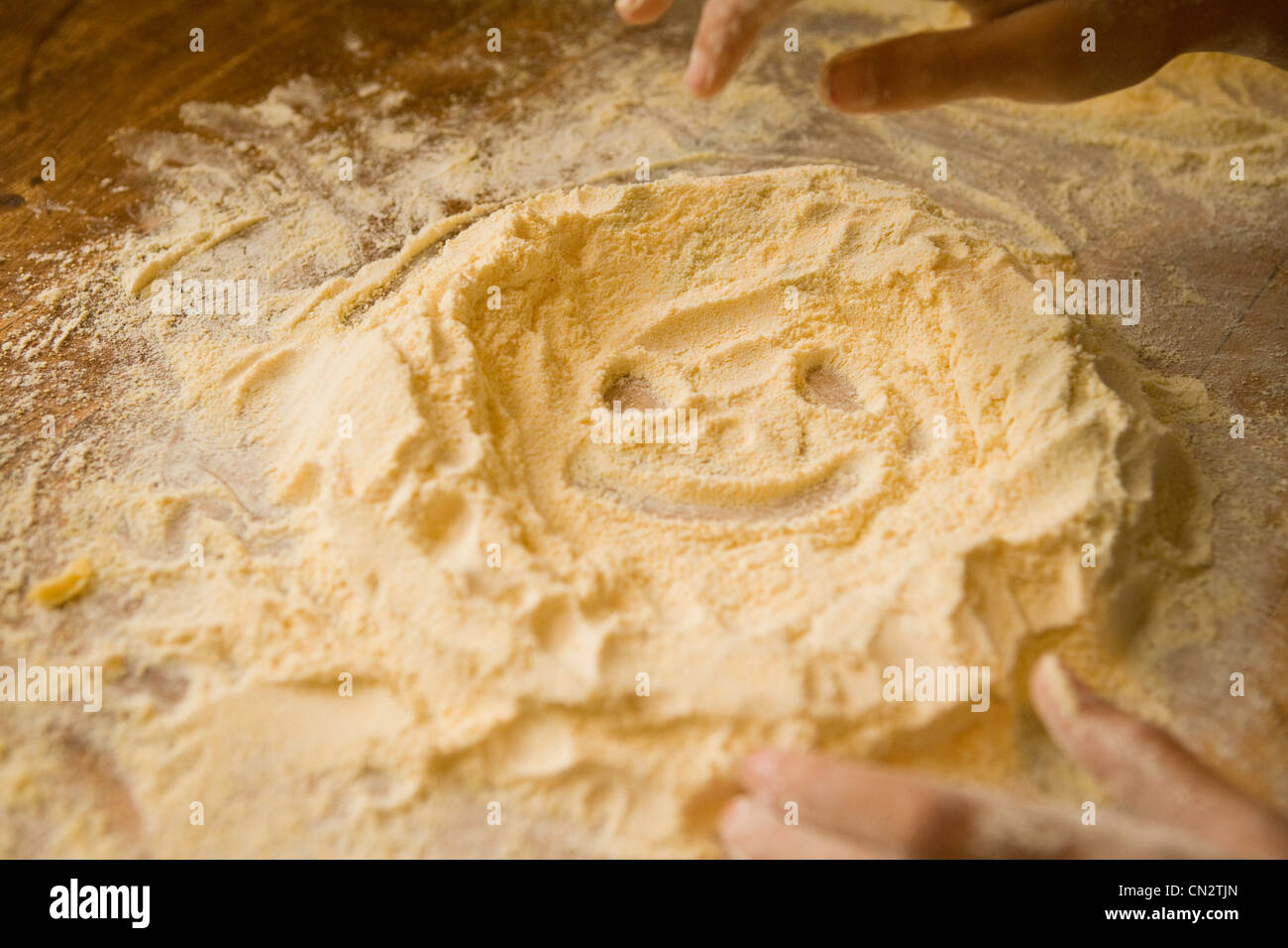 Child baking with smiley face in flour Stock Photo - Alamy