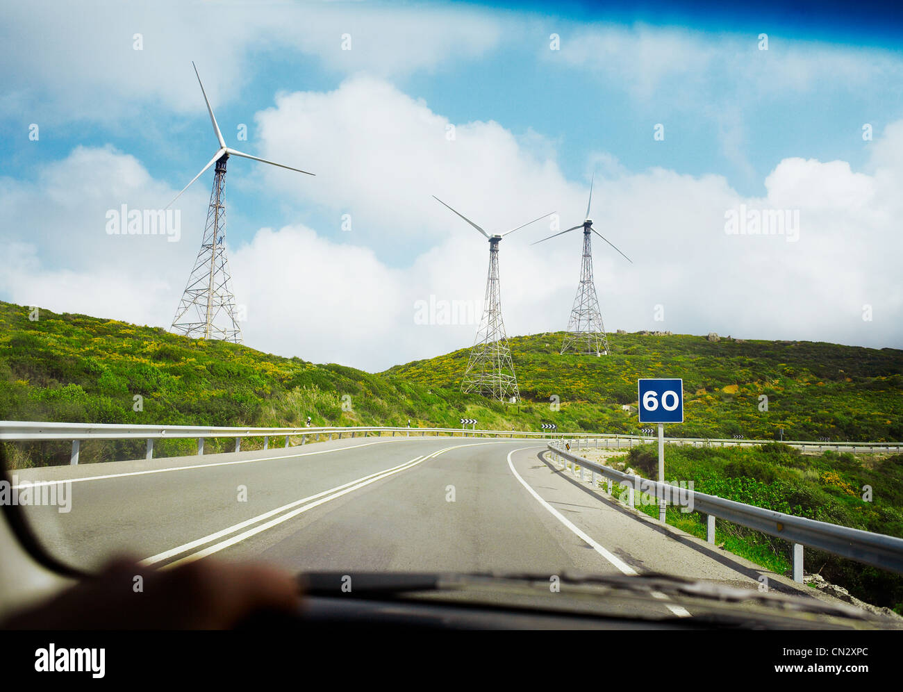 View of wind turbines and road through car windscreen Stock Photo - Alamy