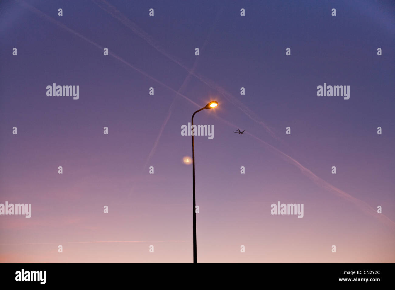 Airplane and street light at dusk Stock Photo - Alamy