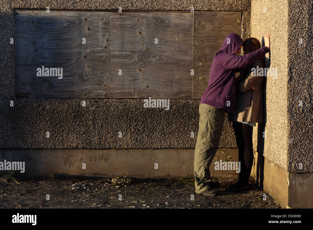 Couple standing by wall Stock Photo - Alamy