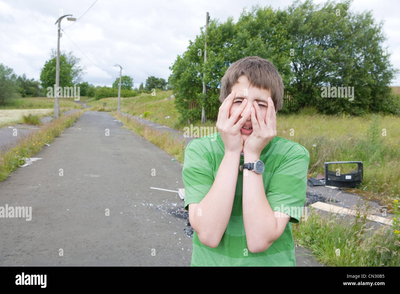 Teenage boy covering face with hands Stock Photo - Alamy