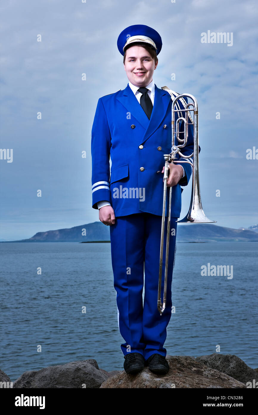 Portrait of young man holding trombone Stock Photo - Alamy