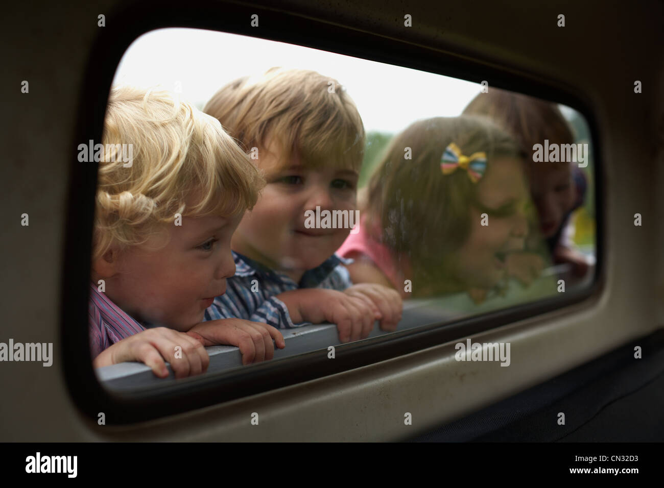 Four children peering through truck window Stock Photo - Alamy