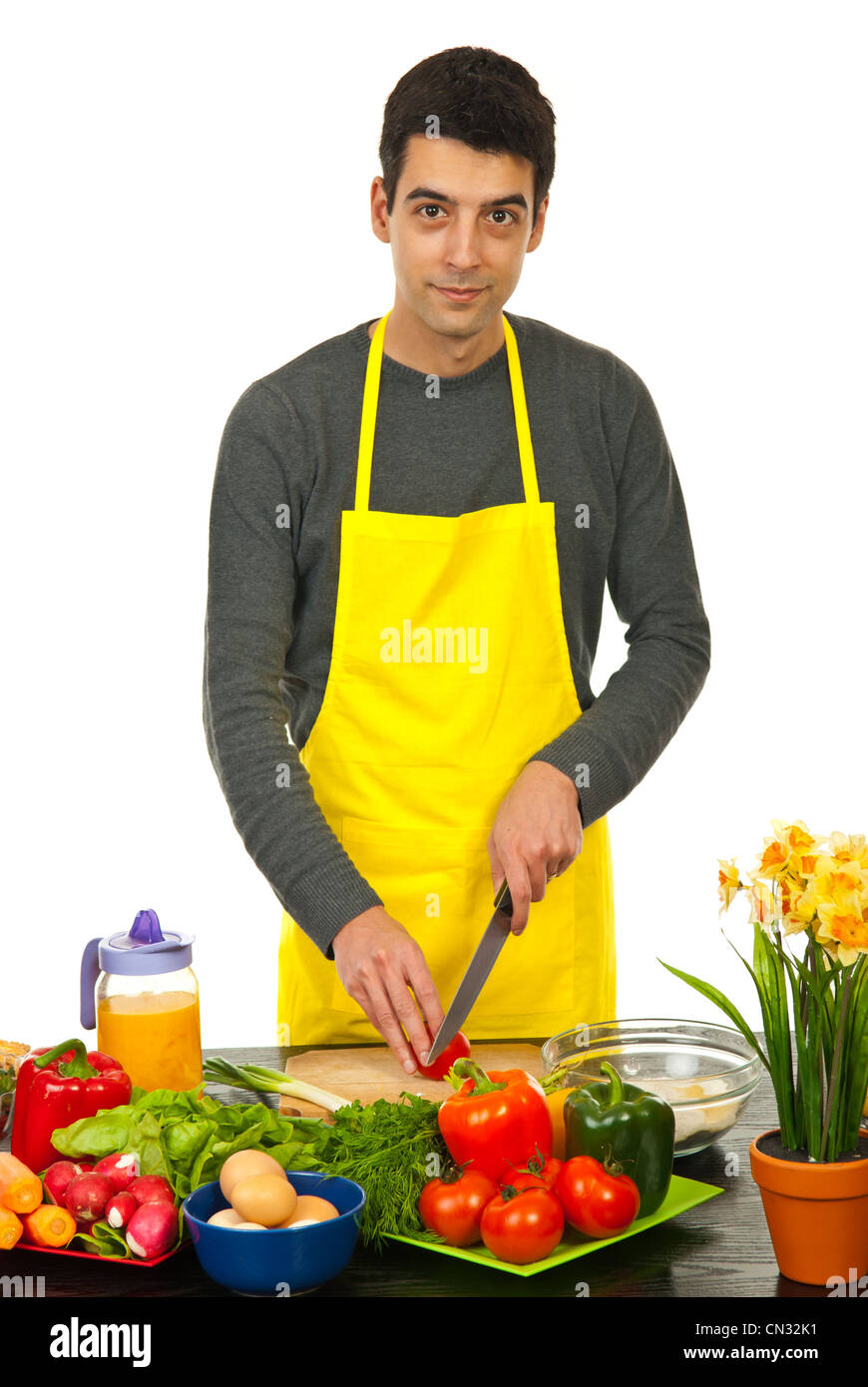 Handsome man with yellow apron cooking home against white background ...