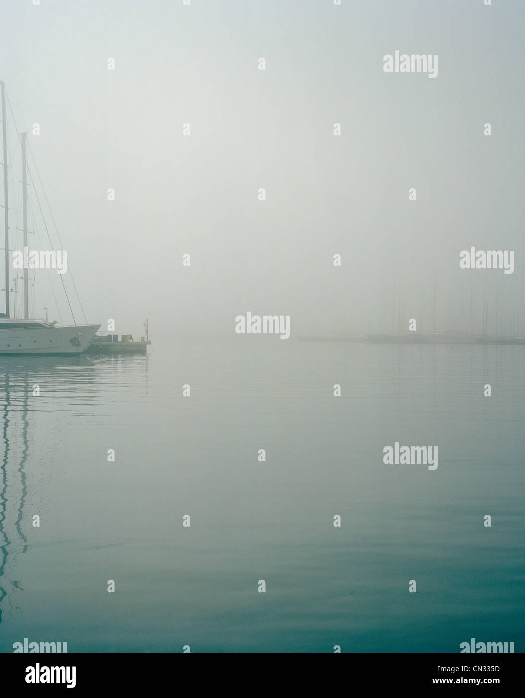 Boats in harbour in fog Stock Photo - Alamy