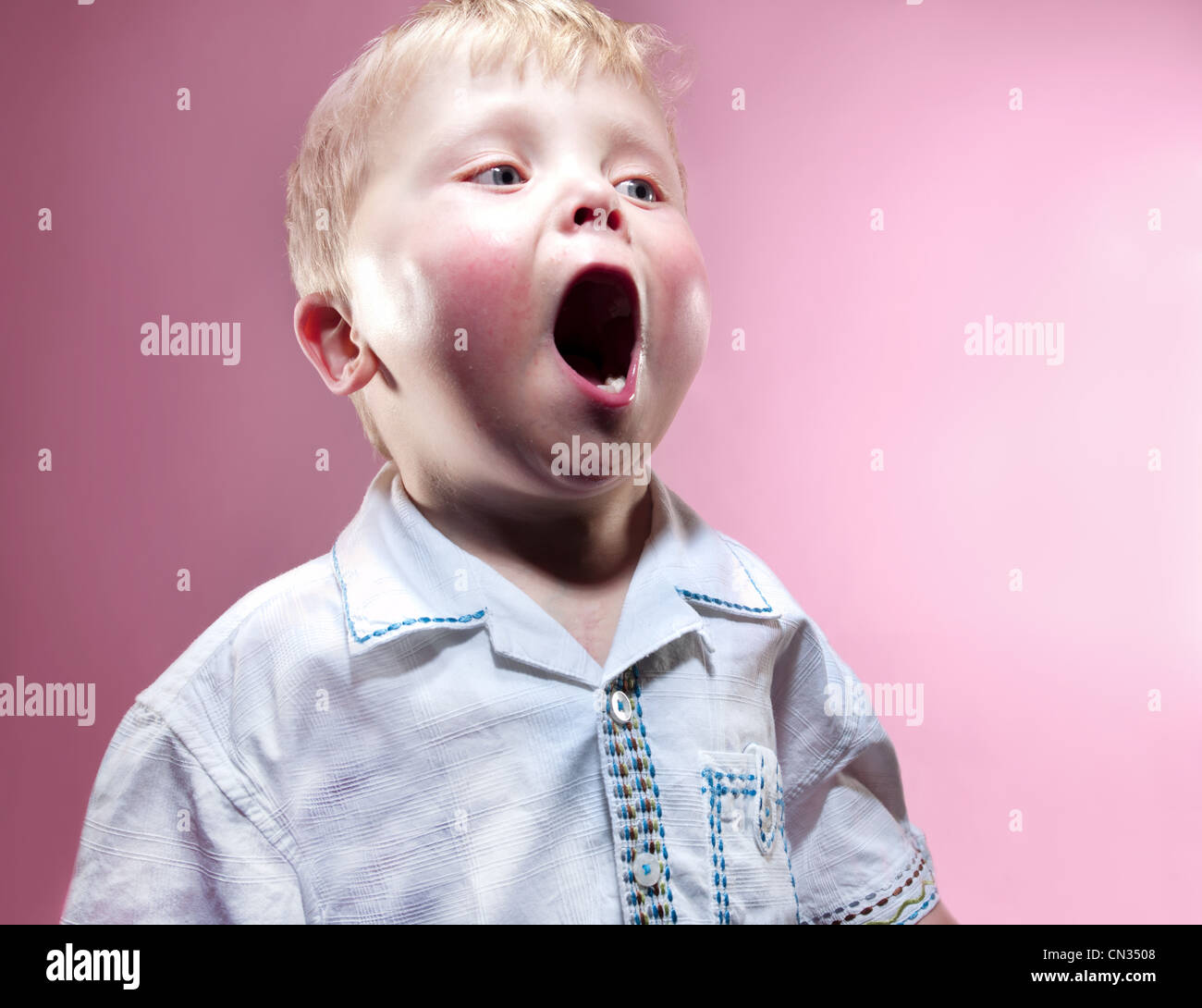 Young boy yawning Stock Photo - Alamy