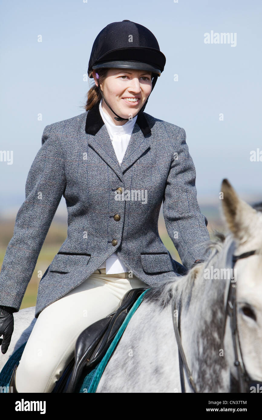 A horse and rider competing in a show jumping event held outside on a ...