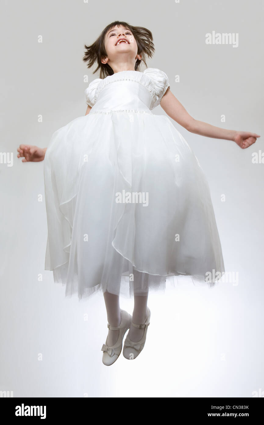 Girl wearing white dress, jumping Stock Photo - Alamy