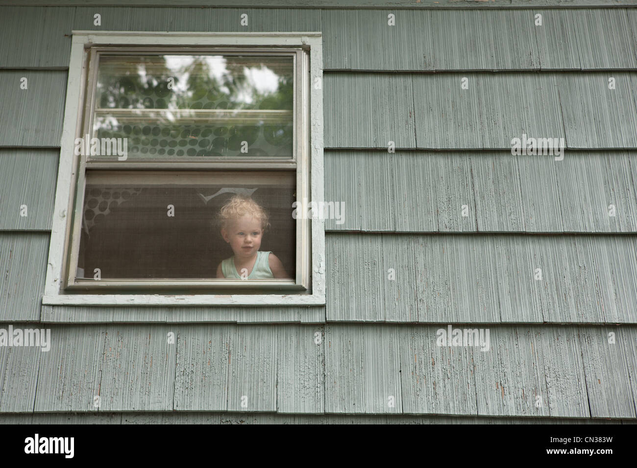 Girl looking through window Stock Photo - Alamy