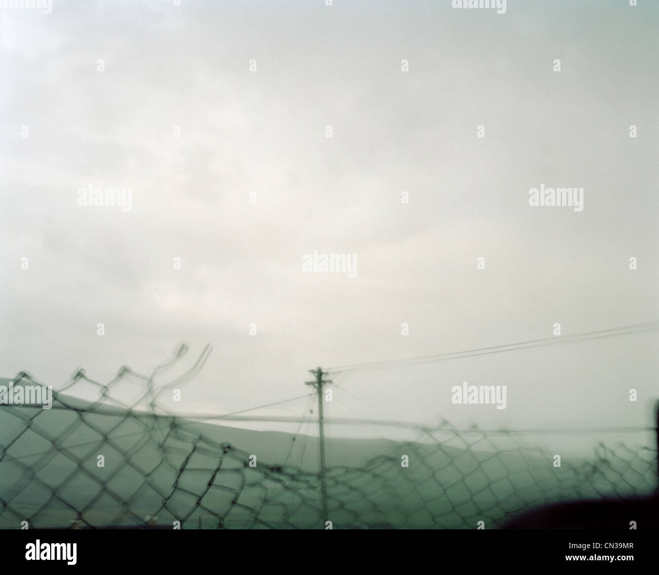 Power lines and broken chain link fence Stock Photo - Alamy