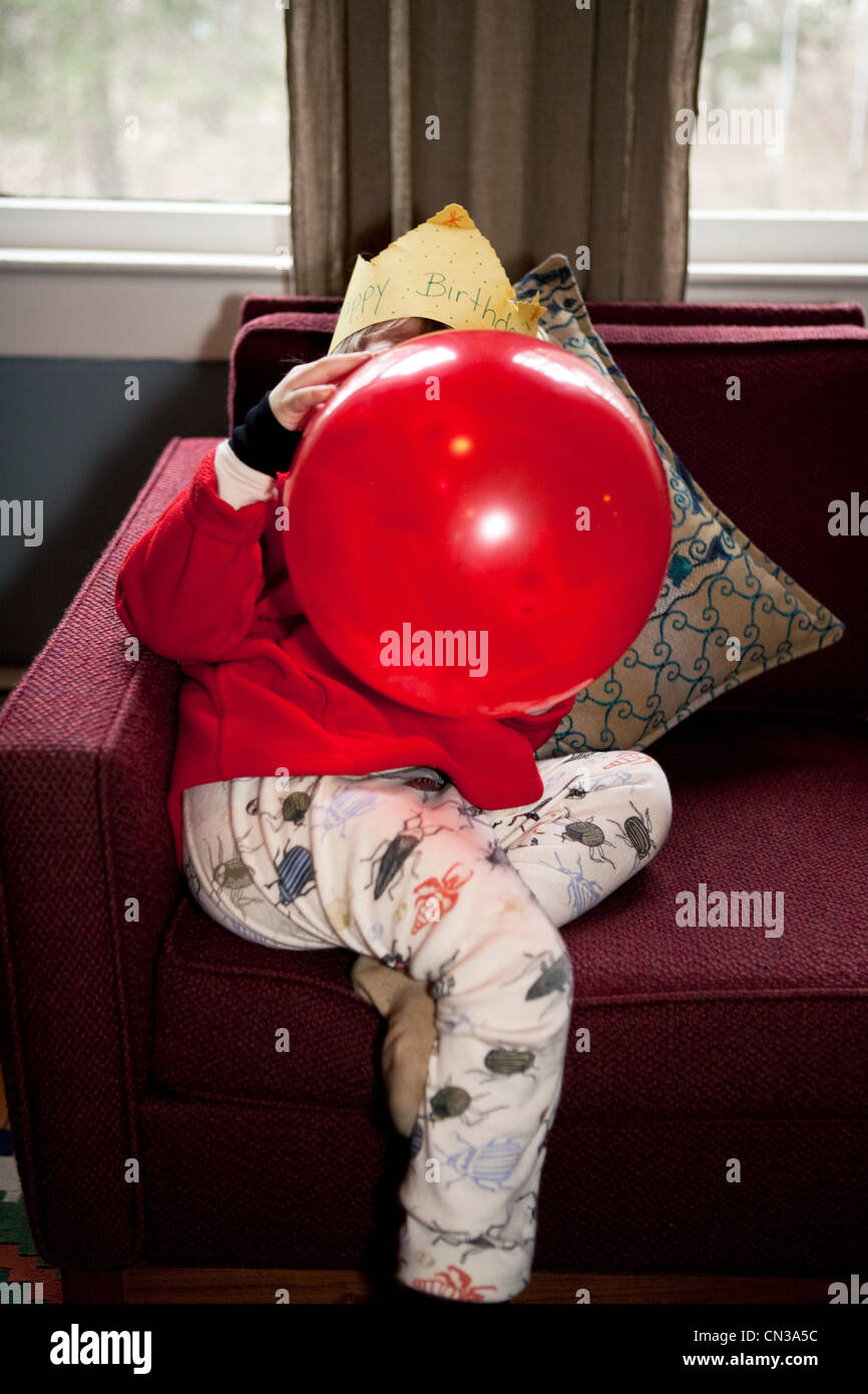 Boy blowing up red balloon hi-res stock photography and images - Alamy
