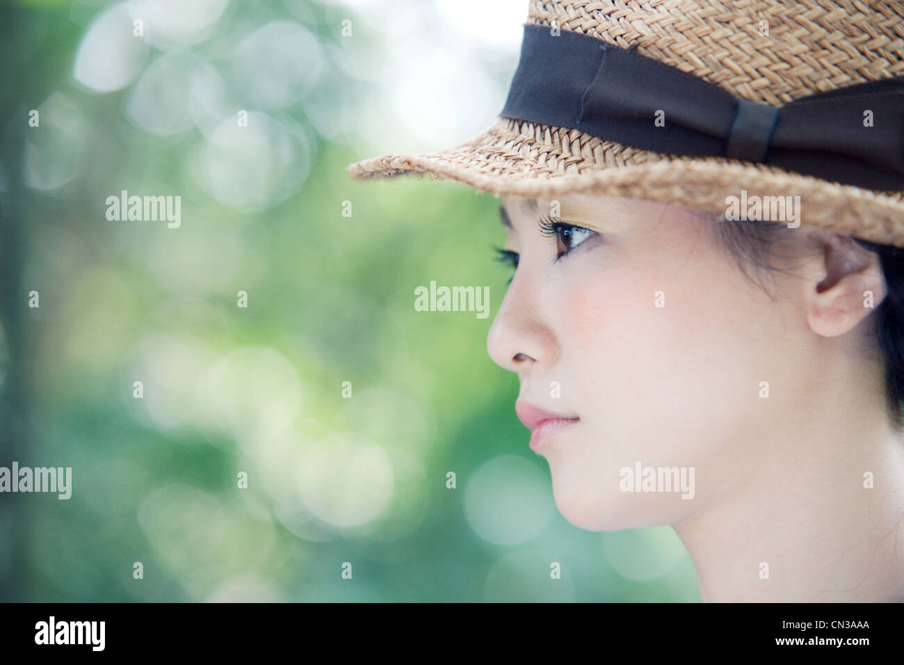 Young woman wearing straw hat, portrait Stock Photo - Alamy