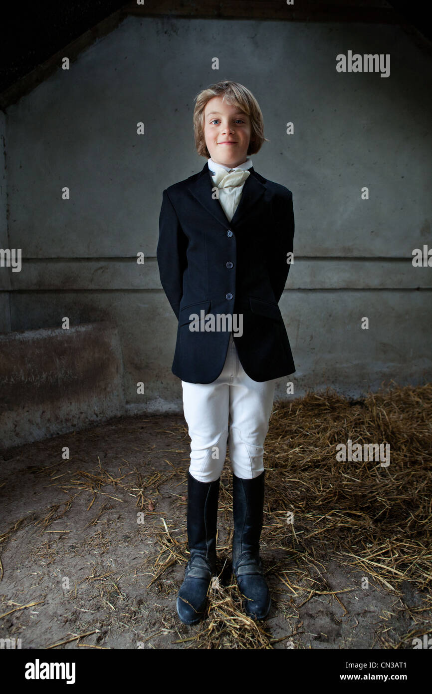 Boy standing in horse riding clothes in stable Stock Photo - Alamy