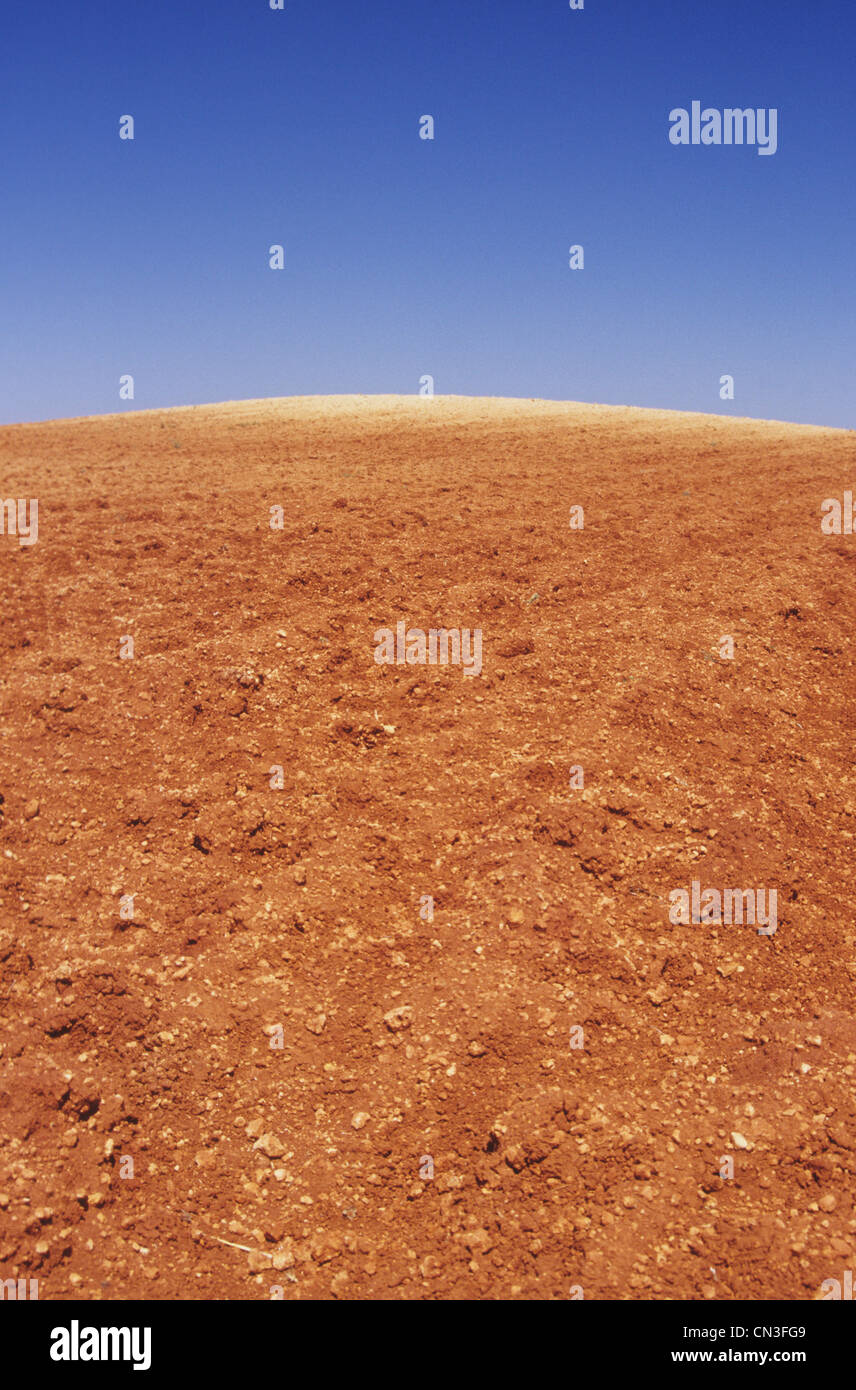 Ploughed field of dry red soil under a blue sky in Castilla y Leon ...