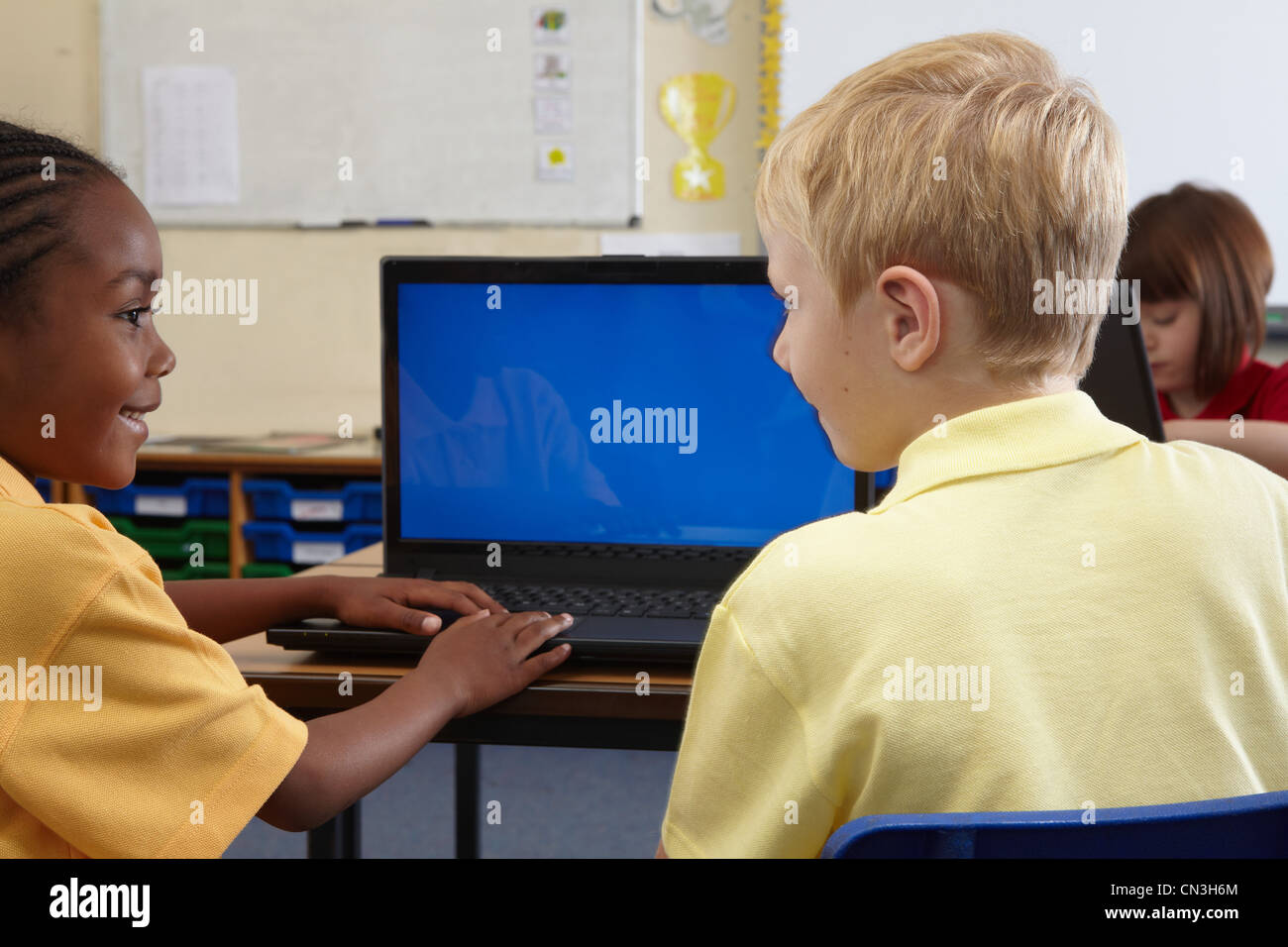 Two school children looking at computer screen in classroom Stock Photo ...