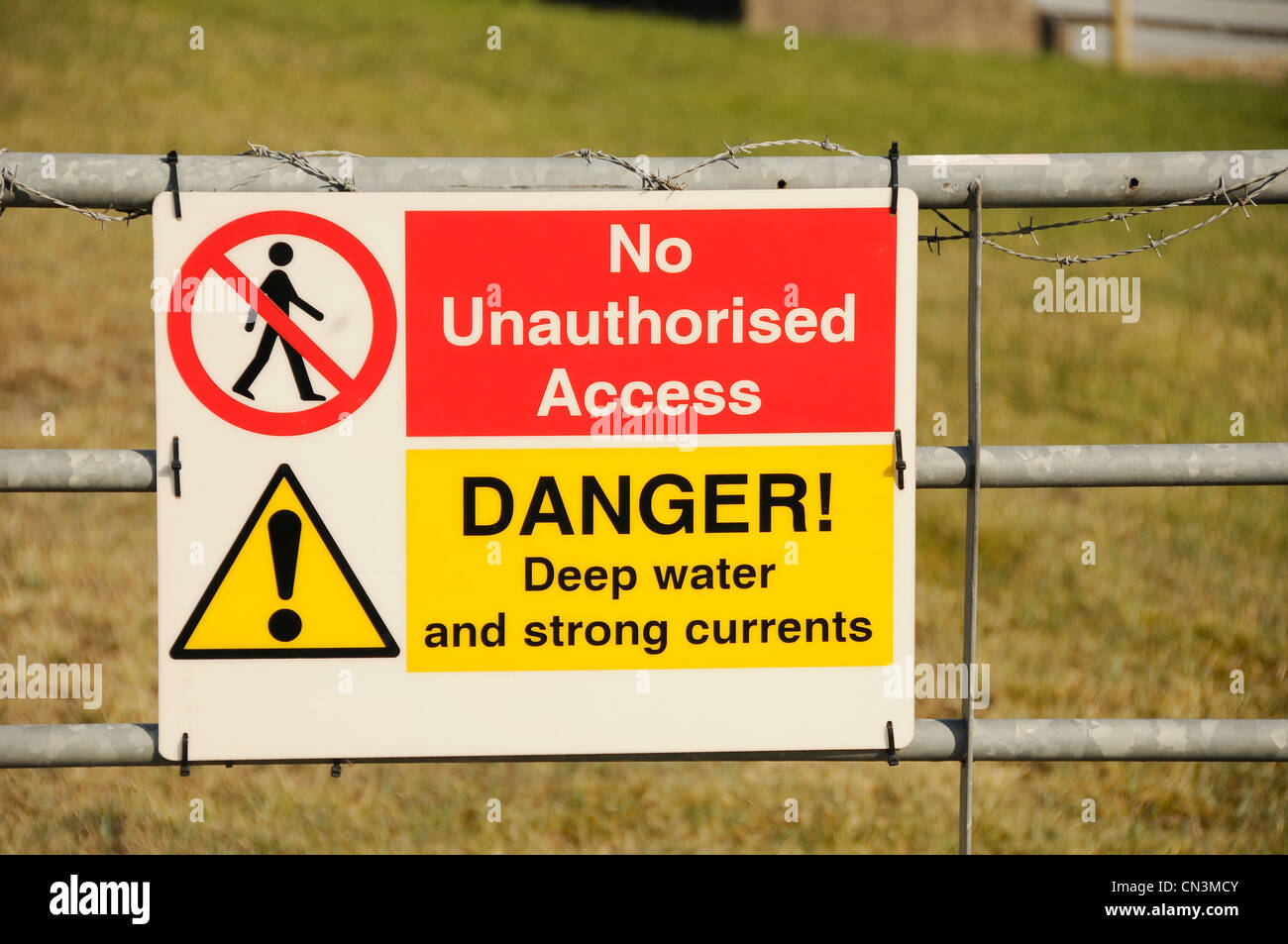 Warning sign for deep water and strong currents next to a lake in the ...