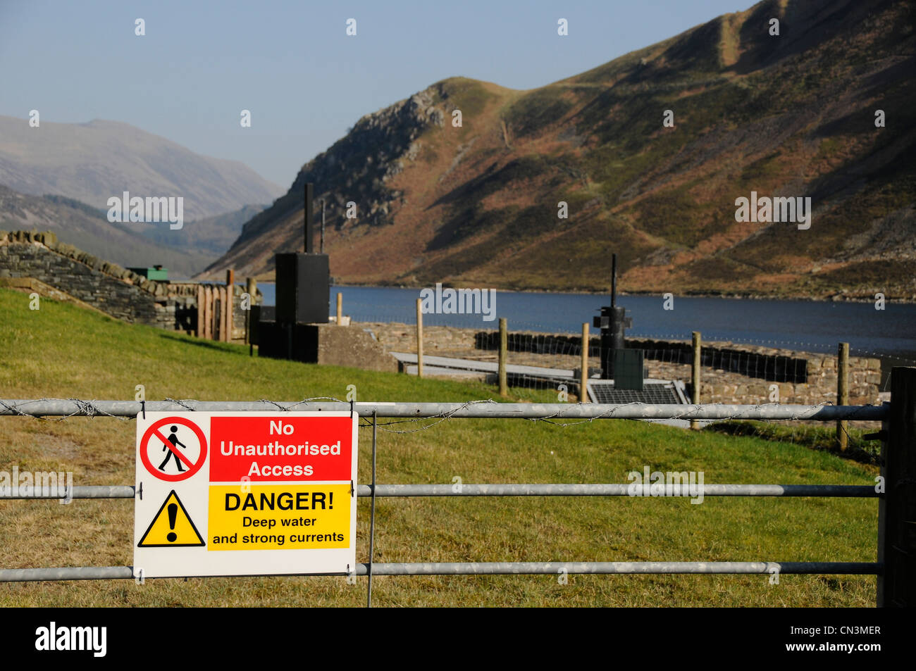 Warning sign for deep water and strong currents next to a lake in the ...