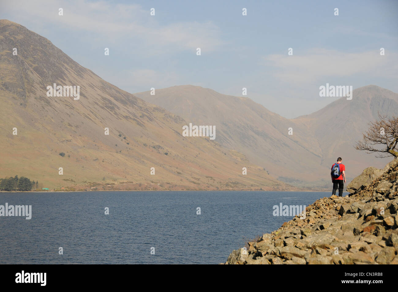 Young man walking on the screes at wastwater in the lake district uk ...