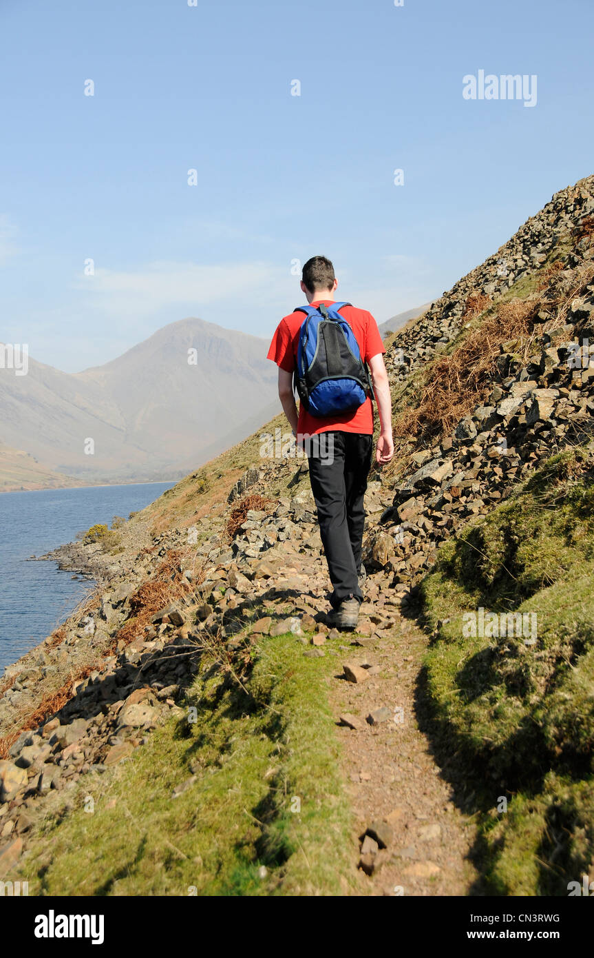Young man walking on the screes at wastwater in the lake district uk ...