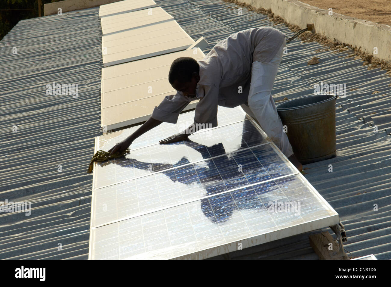 Young boy cleans dust of solar panels in Africa Stock Photo - Alamy