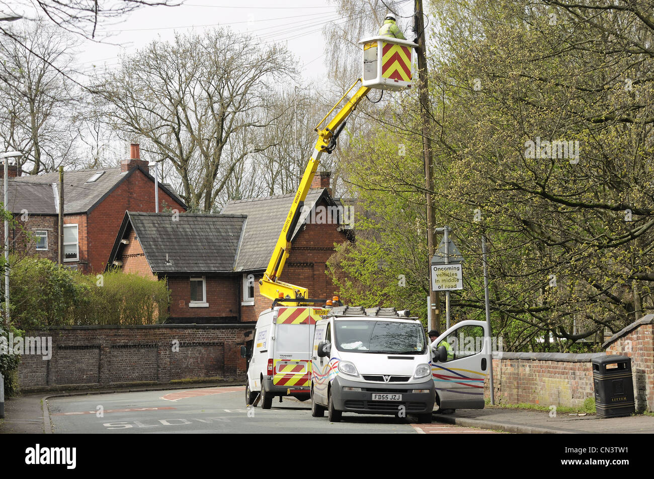 Openreach vehicles in street with engineer working on telephone pole ...
