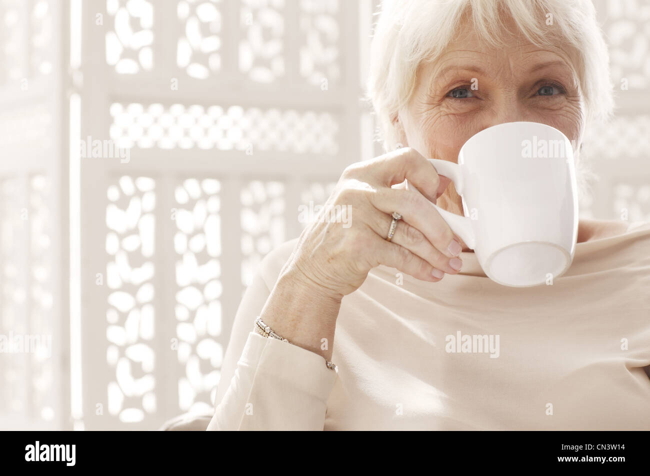 Senior woman drinking coffee, portrait Stock Photo - Alamy