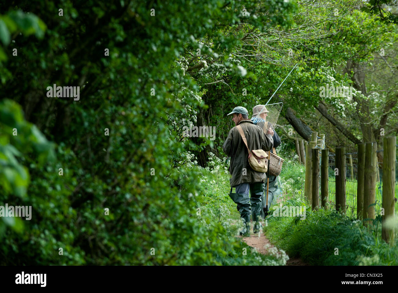 Two people on a path going fishing Stock Photo - Alamy
