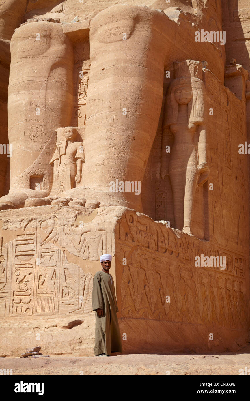 Egypt - Abu Simbel Temple, Egyptian man standing under Ramses II statue ...